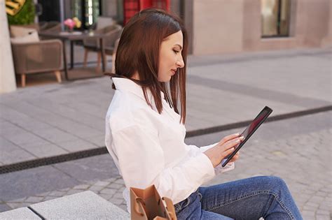 젊은 아름 다운 여자가 도시를 걷는다 휴대 전화와 태블릿을 가진 거리에서 소녀의 초상화 패키지 구매 및 쇼핑 젊은 아름 다운 여자가 도시를 걷는다 온라인 작업 원격 학습