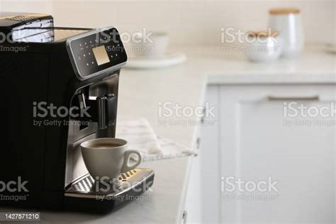 부엌의 흰색 대리석 조리대에 커피 한 잔이있는 현대 전기 에스프레소 기계 커피메이커에 대한 스톡 사진 및 기타 이미지 커피메이커 커피 마실 것 부엌 Istock