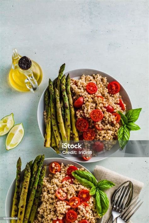 샐러드 글루텐 밀 구운 아스파라거스와 체리 토마토 Tahini 참 깨 파스타 소스와 라임 주스와 테이블에 접시에 체 강 질병을