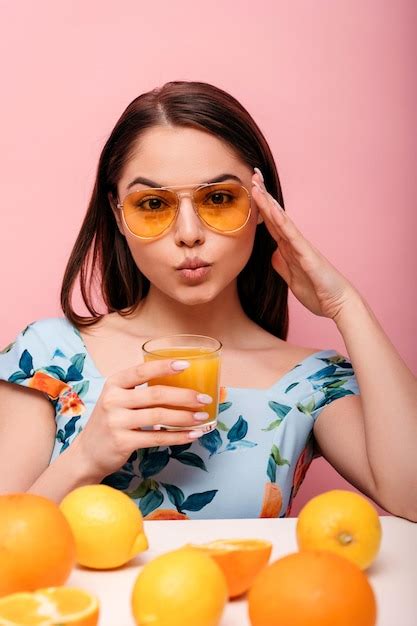 Premium Photo Smiling Woman Holding Orange Juice And Posing At Orange