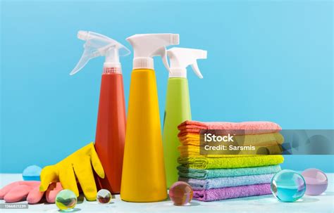 파란색 배경에서 청소를위한 컬러 용품 세제 고무 보호 장갑 및 헝겊 무지개 색상의 병을 스프레이합니다 봄 청소 가정의 개념