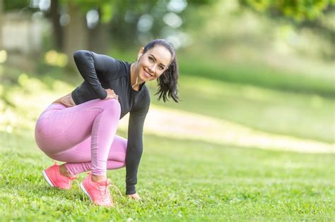 Premium Photo Young Woman Runner Warming Up Before Running