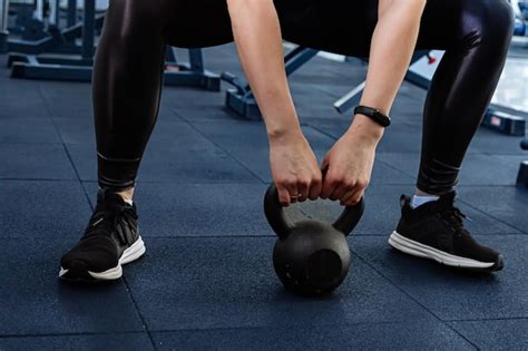 Premium Photo Woman Performing Kettle Squat Exercise With Kettlebell