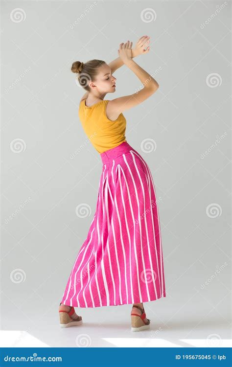 Het Meisje Staat Met Haar Rug In Volle Groei En Haar Armen Zijn Bovenaan Opgevoed Stock