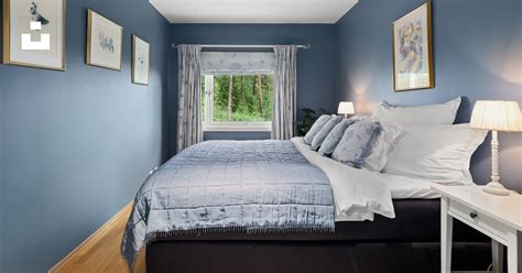 깔끔하게 정돈된 침대와 벽에 걸린 그림이 있는 침실입니다 사진 Unsplash의 무료 실내 이미지