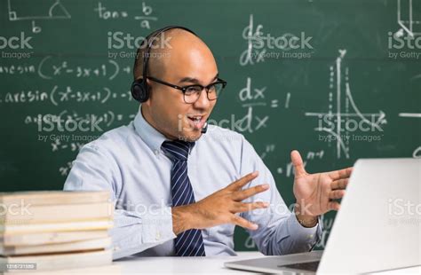 온라인 비디오 컨퍼런스 라이브 스트림을 노트북으로 가르치는 헤드셋을 착용하고 앉아있는 인도 의 젊은 교사 남자 아시아 교사는