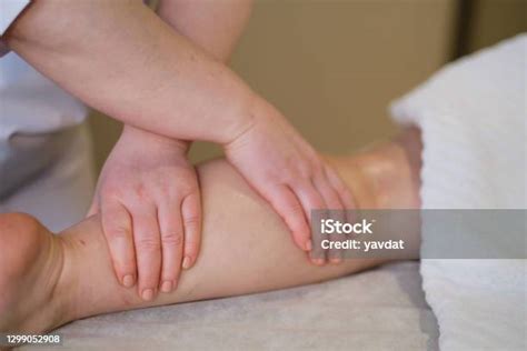 인간의 종아리 근육을 마사지 손의 세부 사항 여성 다리에 압력을 가하는 치료사 스파 살롱에서 젊은 여성의 다리를 마사지 치료사의 손 젊은 여성을위한 스파 살롱에서 바디 케어