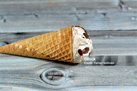 바삭한 웨이퍼 콘에 초콜릿 칩 조각을 토핑한 아이스크림 바닐라 콘 웨이퍼 비스킷에 차가운 아이스크림 돌리기를 녹이는 선택적 초점 거품 내기에 대한 스톡 사진 및 기타 이미지