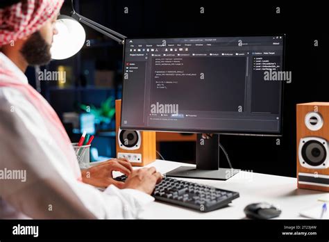 Muslim Man Sitting At Desk And Coding On Computer Showcasing Process