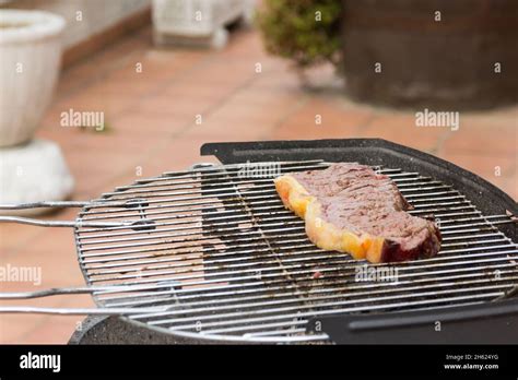 Beef Steak Cooking On Barbecue Grill Charcoal To Cook Raw Meat Sunday