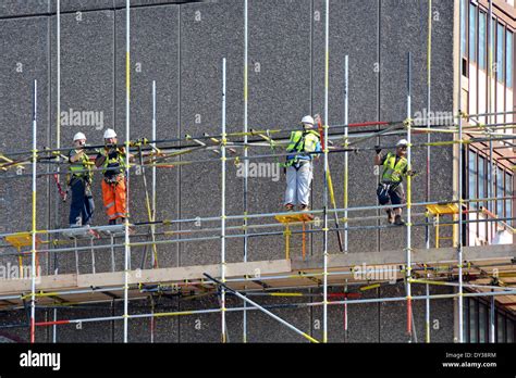 Workmen Erecting Scaffolding Around Obsolete Social Housing Block Prior To Demolition For Re