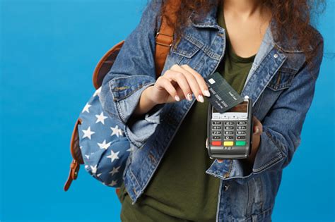 데님 옷 배낭 홀드 신용 카드 파란색 배경 스튜디오 초상화에 고립에서 젊은 아프리카계 미국인 소녀 십 대 학생 고등학교 대학 대학 컨셉의 교육 복사 공간을 모의 가방에 대한