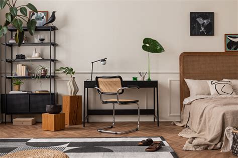 모형 포스터 프레임 검은색 책상 아늑한 침대 등나무 의자 무늬가 있는 깔개 나무 벤치 세련된 램프 선반 및 개인 액세서리로 방 인테리어를 창의적으로 구성했습니다 가정 장식