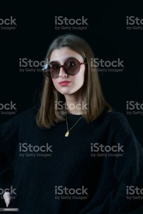 어두운 배경위에 포즈를 취하면서 카메라를 바라보는 선글라스를 착용한 세련된 여성 18 19세에 대한 스톡 사진 및 기타 이미지 18 19세 갈색 머리 개념 Istock
