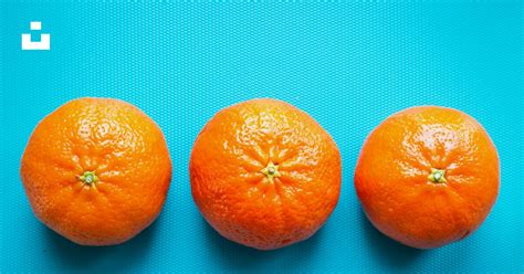 파란색과 흰색 물방울 무늬 직물에 주황색 과일 2개 사진 Unsplash의 무료 과일 이미지