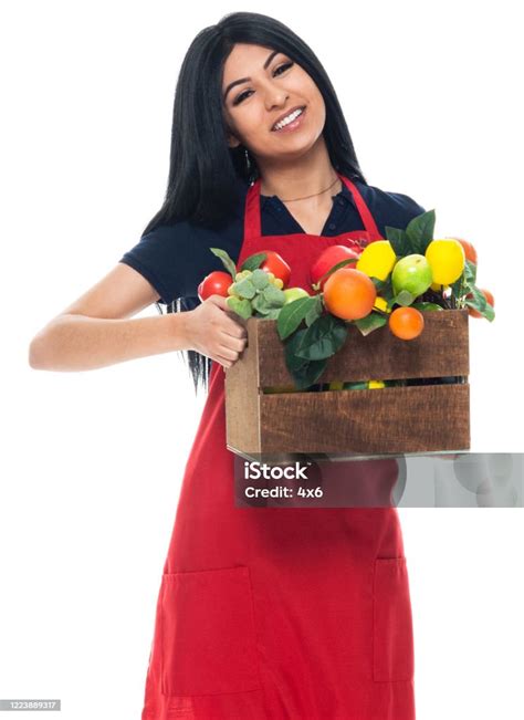 폴로 셔츠를 입고 상자를 들고 흰색 배경 앞에 서있는 라틴 아메리카와 히스패닉 인종 여성 농장 노동자 농부에 대한 스톡 사진 및