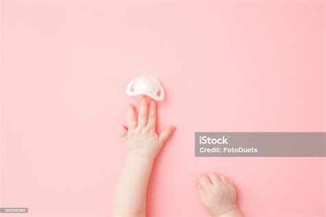 밝은 분홍색 바닥 배경에 흰색 Soother 후 도달 유아 손 파스텔 색상입니다 근접 촬영 첫 아기 장난감 하향하 보기 젖꼭지에 대한 스톡 사진 및 기타 이미지 Istock