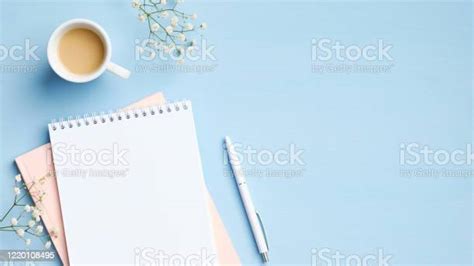 플랫 레이 빈 메모장 커피 한 잔 펜과 파란색 배경에 꽃과 상단보기 여성스러운 작업 공간 최소한의 스타일의 홈 오피스 데스크 비즈니스 및 교육 개념 꽃 식물에 대한 스톡