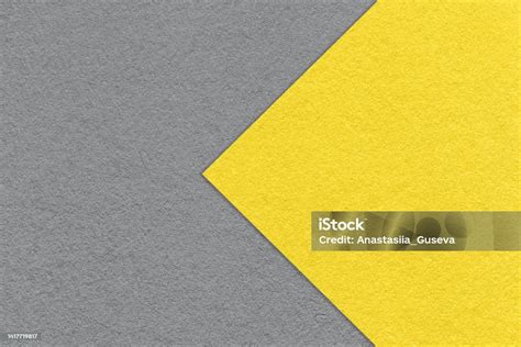 紙の灰色の背景のテクスチャ黄色の矢印マクロと半分の2色緻密なクラフト段ボールの構造 からっぽのストックフォトや画像を多数ご用意