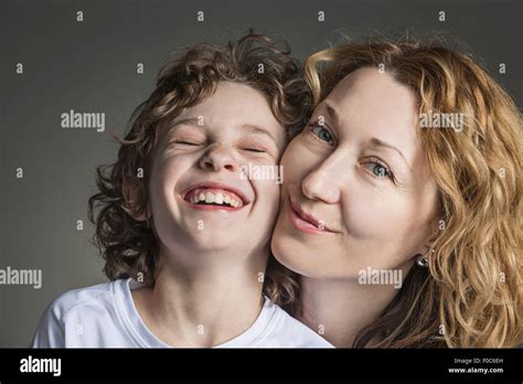 Close Up Portrait Of Mother With Cheerful Son Over Gray Background