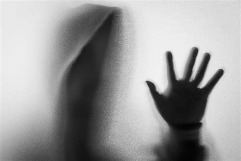 공포와 후드 자 켓 남자의 그림자 부분 하나는 유리에 손 젖 빛된 유리 뒤에 위험한 남자입니다 미스터리 남자입니다 할로윈