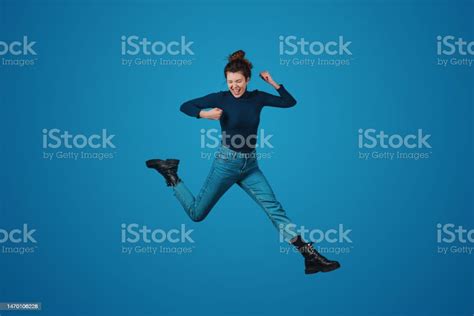 파란색 배경 위에 고립된 긍정적인 감정을 표현하는 즐거운 여자 점프의 전체 길이 보기 긍정적 인 사람 사람들의 라이프 스타일 초상화입니다 매력적인 아름다운 소녀 25 29