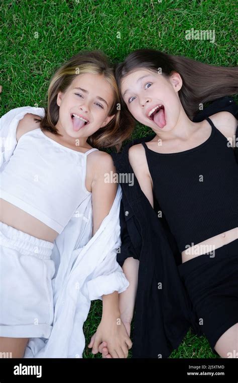Fraternal Twins Sisters Blonde And Brunette Teen Girls In Fashionable Black And White Clothes