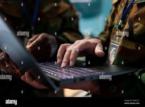 Diverse Military Staff Analyzing Battlefield Data Via Satellite Imagery On A Laptop