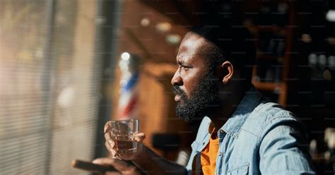 바 카운터에 앉아 있는 동안 시가와 알코올 음료 한 잔을 들고 있는 잘생긴 진지한 신사 사진 Unsplash의 30 34 년 이미지