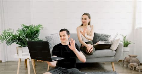 요가 코치의 젊은 즐거운 커플 연꽃 자세에 앉아 요가 운동 후 집에서 재미 친구들과 노트북으로 화상 통화를하고 손을 흔들고 웃고 건강한 라이프 스타일 사진