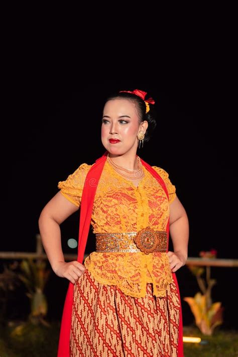 Balinese Woman With Makeup While Wearing An Orange Dress Called Kebaya