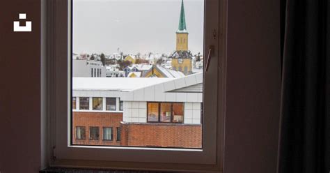 흰색 이불이 있는 침대와 도시 전망을 감상할 수 있는 창문 사진 Unsplash의 무료 트롬쇠 이미지