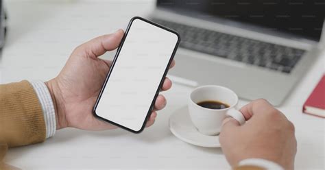 빈 화면 스마트폰을 들고 커피 한 잔을 마시는 사업가의 클로즈업 뷰 사진 Unsplash의 사무실 이미지
