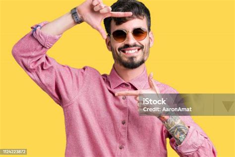 잘생긴 젊은이 웃 고 손으로 만드는 프레임와 행복 한 얼굴로 손가락 격리 된 배경 위에 선글라스를 착용 창의력과 사진 개념입니다 개념에 대한 스톡 사진 및 기타 이미지