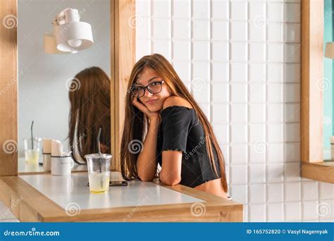 Young Brunette Girl In Glasses Dressed In Black T Shirt Sittting At A