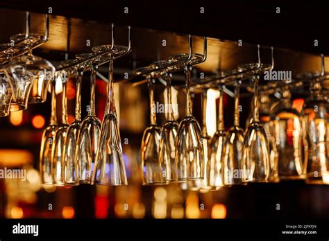 Empty Clean Upside Down Crystal Wine Glasses Hanging From The Bar In