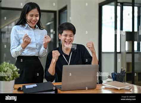 Two Cheerful And Overjoyed Asian Office Workers Are Celebrating Their Project Success Together