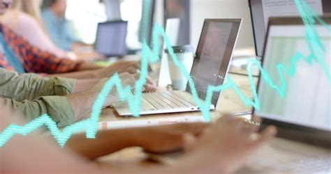 Image Of Data Processing And Diagrams Over Diverse Business People Using Laptops In Office Stock