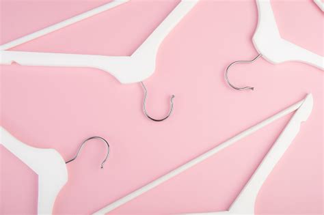 옷에 대 한 몇 가지 흰색 옷걸이 공간을 채우는 분홍색 배경에 거짓말 서명 개념입니다 평평한 누워 0명에 대한 스톡 사진 및 기타 이미지 Istock
