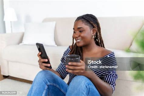 집에서 소파에서 휴식을 취하면서 휴대 전화를 사용하는 젊은 여성의 샷 가정 생활에 대한 스톡 사진 및 기타 이미지 가정 생활 놀기 독점 Istock