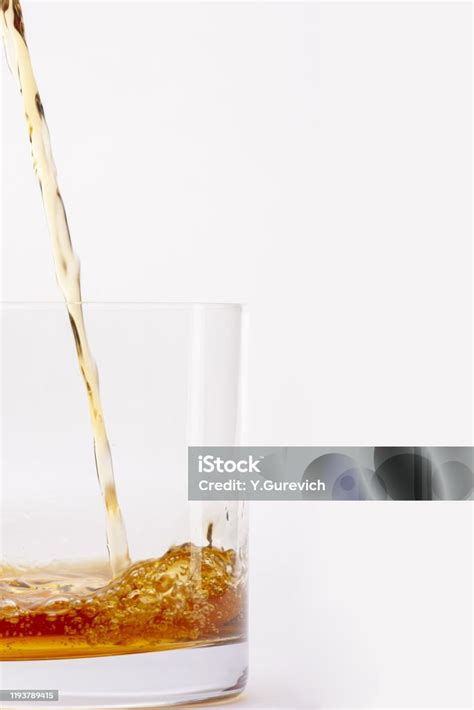 럼주나 위스키와 비슷한 주류를 흰색 배경에 쏟아부은 주류를 입은 영혼을 위한 우아한 유리를 클로즈업합니다 텍스트에 대한 장소가 있습니다 버번 위스키에 대한 스톡 사진 및