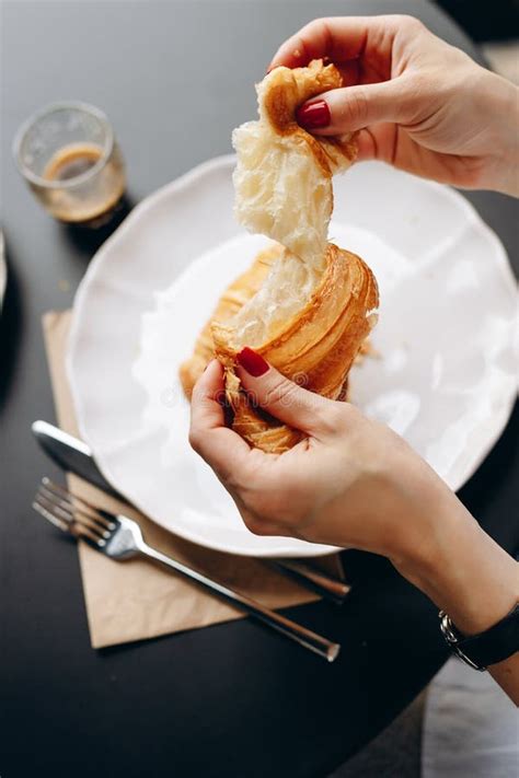 A Girl With A Red Manicure Tears A French Croissant The Layers Are