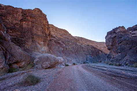 A Dramatic Canyon Road Winding Through Rocky Cliffs In A Remote Desert