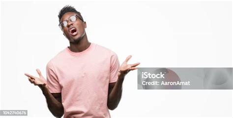분홍색 T셔츠 미친과 미친 소리 하 고 적극적인 식와 팔 제기 함 입고 젊은 아프리카계 미국인 남자 좌절 개념입니다 T 셔츠에 대한 스톡 사진 및 기타 이미지 Istock