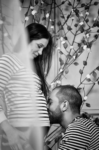 매력적인 국제 커플의 흑인과 백인 사진 보고 서로 앉아서 무슬림 남자와 그의 임신한 아내의 배꼽 키스 가정 생활에 대한 스톡 사진 및 기타 이미지 Istock