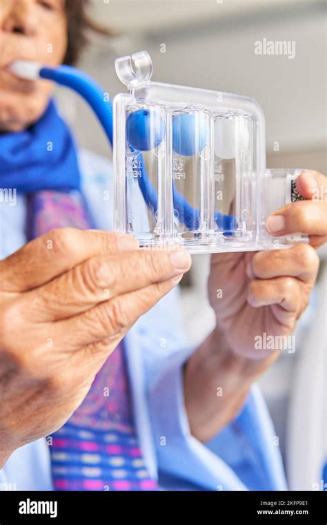spirometer for breathing exercises senior woman in hospital room