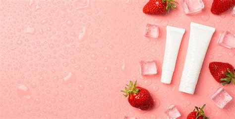 레이블 딸기 얼음 큐브가없는 두 가지 크기의 흰색 튜브의 상단 보기 사진과 왼쪽에 카피 스페이스와 고립 된 파스텔 핑크 배경에 오른쪽에 드롭 각얼음에 대한 스톡 사진 및