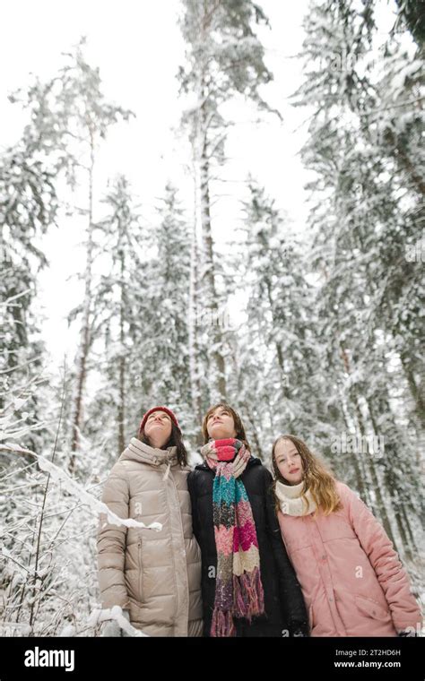 Funny Teen Sisters And Their Mother Having Fun On A Walk In Snow