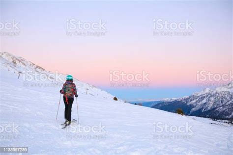 여자 스키어는 화창한 스키 리조트 아마추어 겨울 스포츠에서 아름 다운 보기에서 즐긴다 상단에 일몰 높은 산 눈 덮인 풍경입니다 이탈리아 알프스 산의 돌로미티 파소 토 날 레