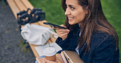 전화 통화를하는 동안 벤치에 앉아있는 웃는 젊은 아가씨의 사진을 잘라냅니다 사진 Unsplash의 휴식 이미지